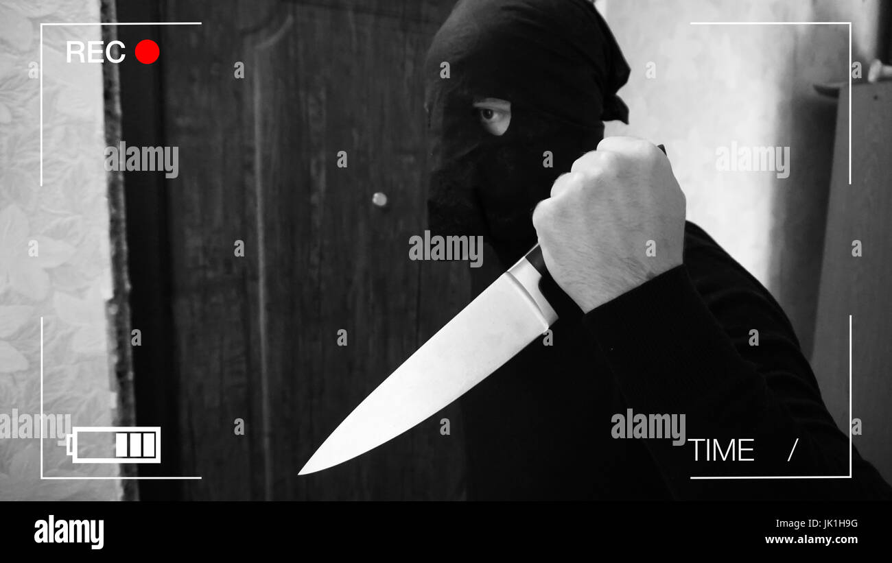 surveillance camera caught the robber in a mask with a knife Stock ...