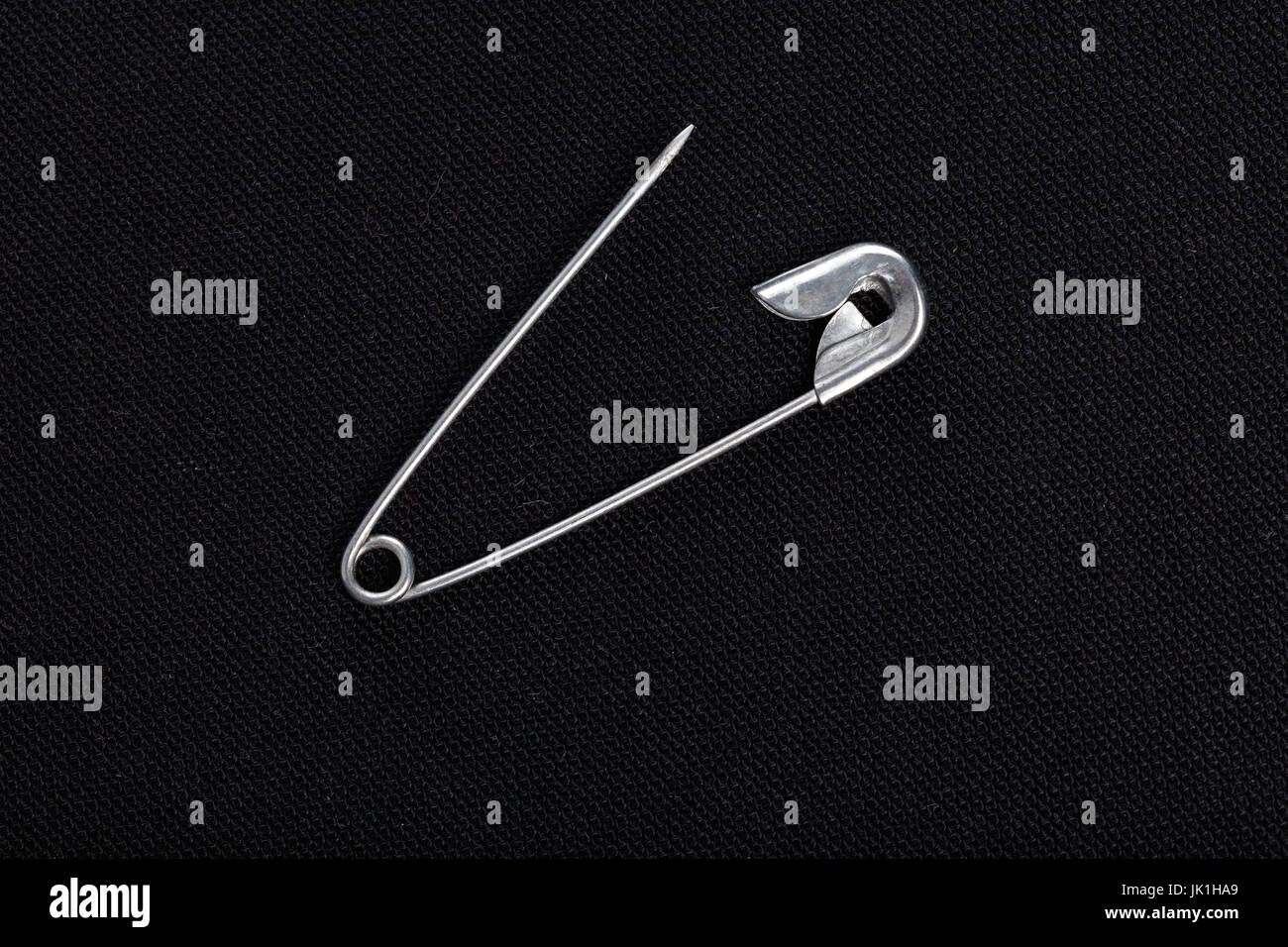 sewing safety pin on a black background Stock Photo - Alamy