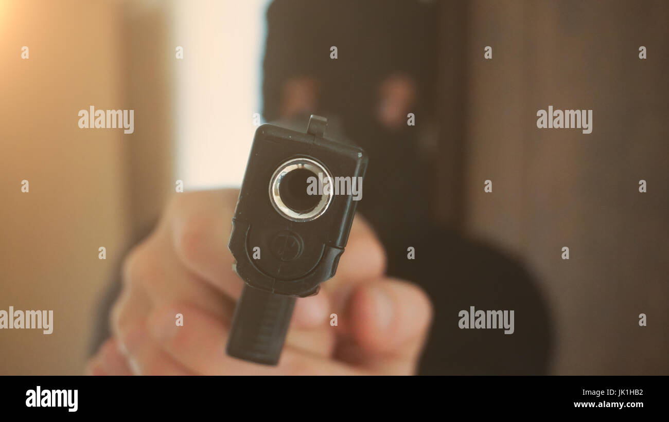 Burglar Wearing Mask Aiming Gun Towards Camera Stock Photo - Alamy