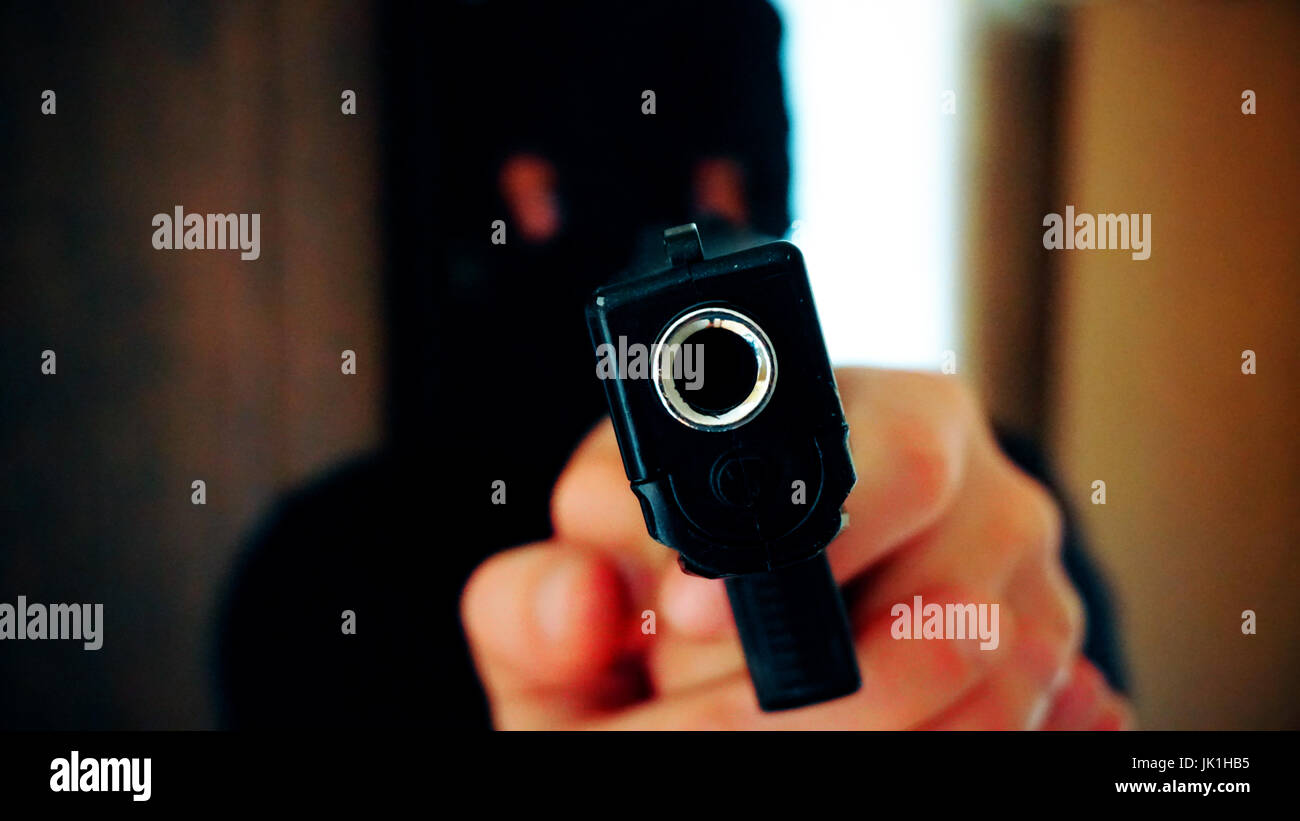 Burglar Wearing Mask Aiming Gun Towards Camera Stock Photo - Alamy