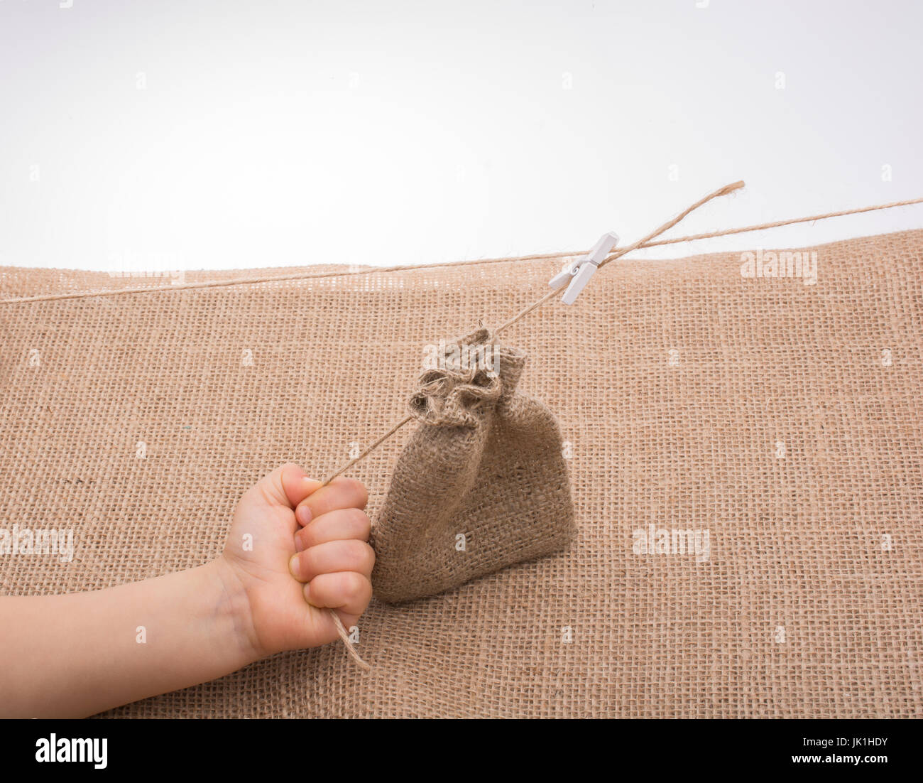 Hand holding an empty little sack made of linen Stock Photo - Alamy