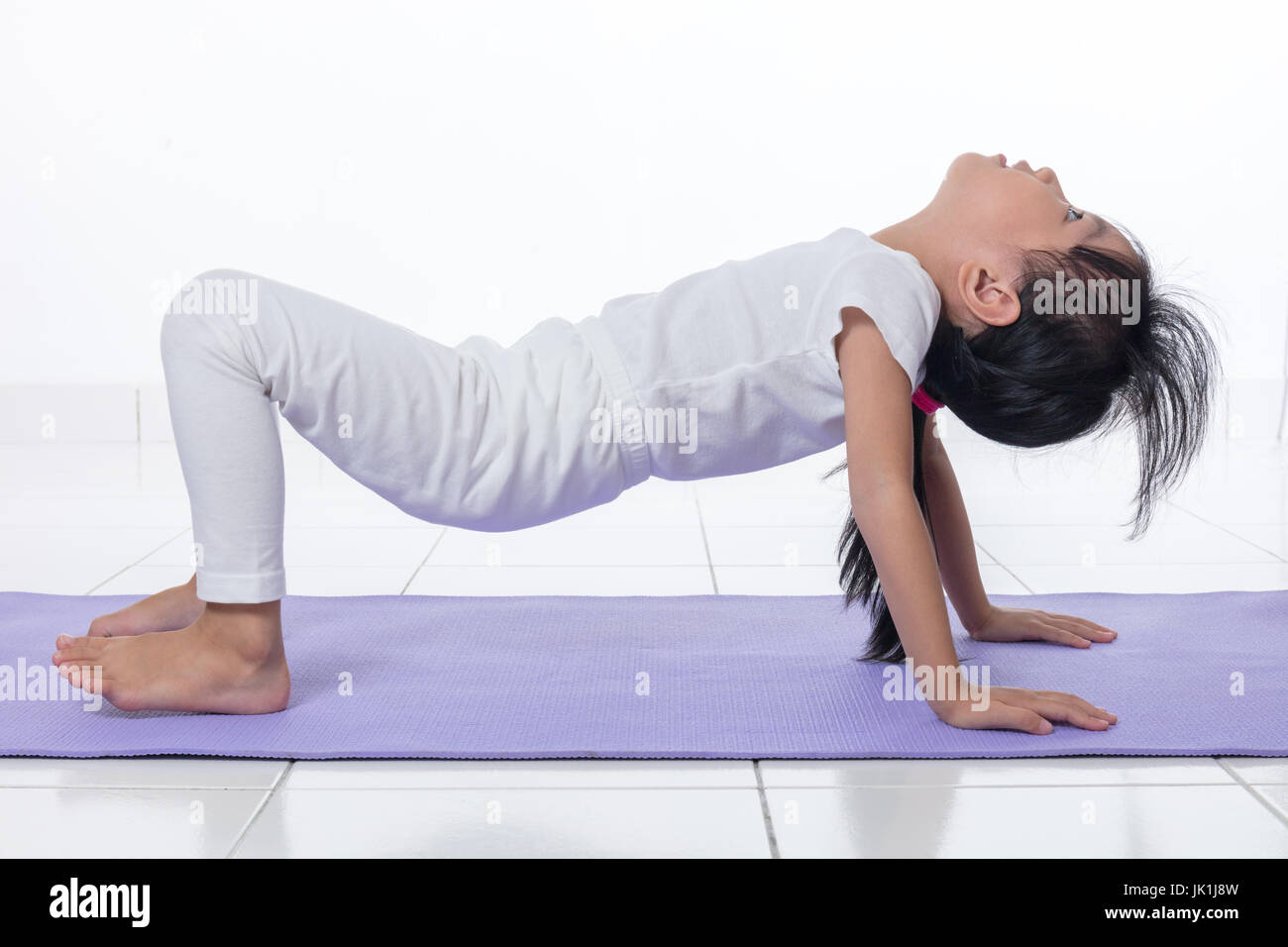 Asian Chinese little girl practicing yoga pose on a mat indoor Stock ...