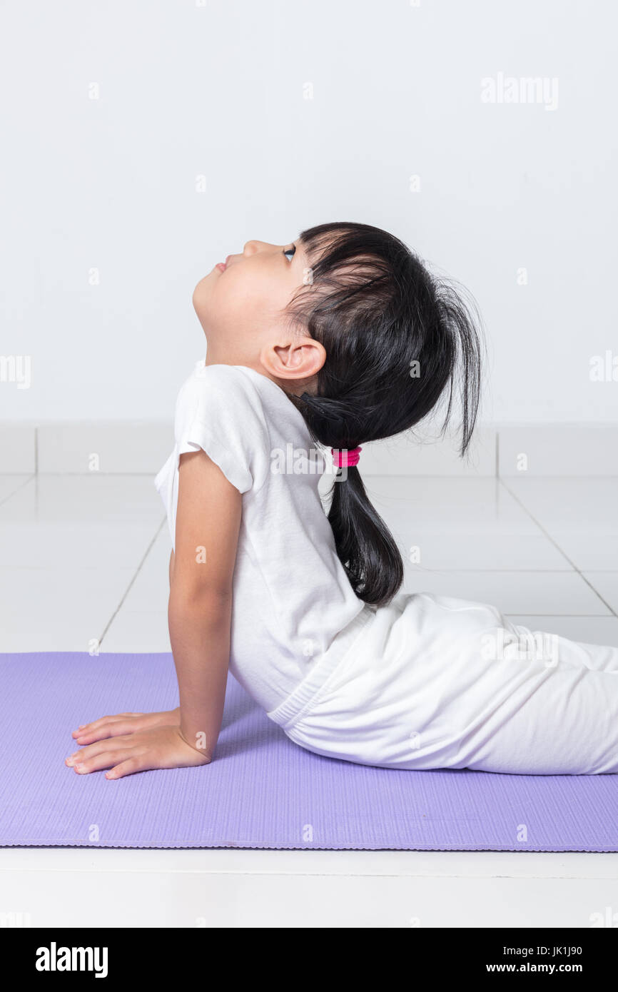 Asian Chinese little girl practicing yoga pose on a mat indoor Stock ...