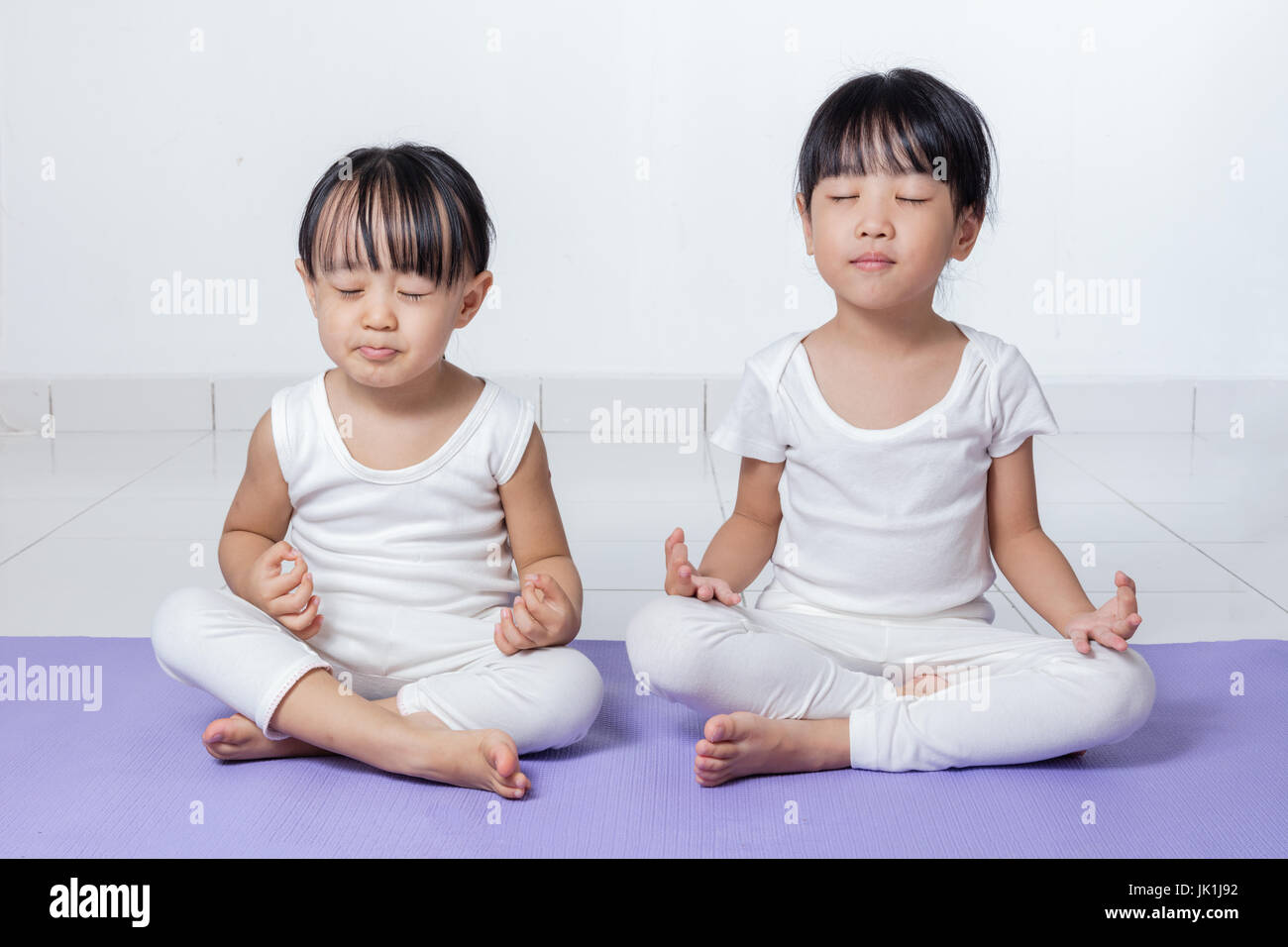 Asian Chinese little girls practicing yoga pose on a mat indoor Stock ...