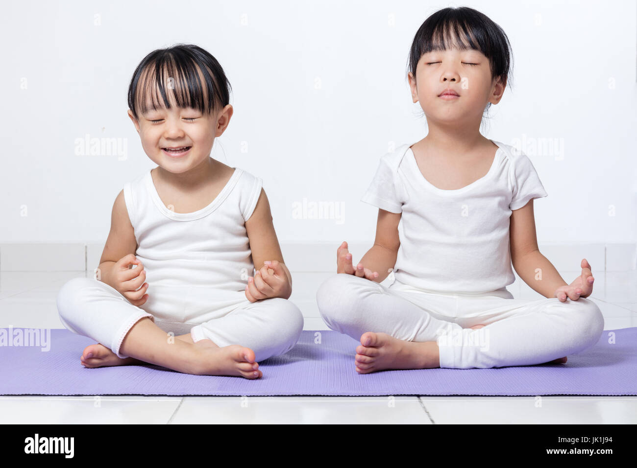 Asian Chinese little girls practicing yoga pose on a mat indoor Stock ...