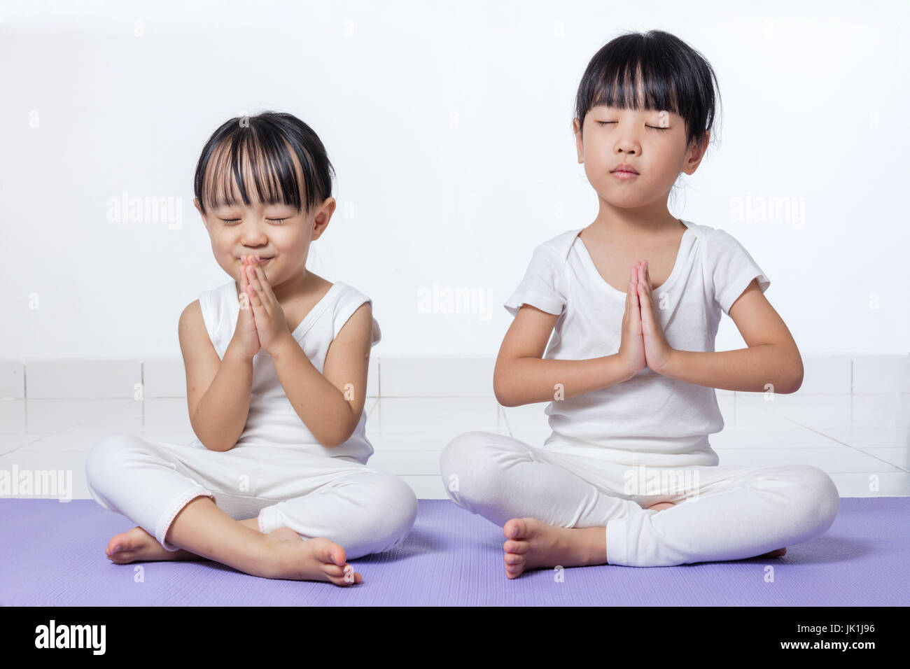 Asian Chinese little girls practicing yoga pose on a mat indoor Stock ...