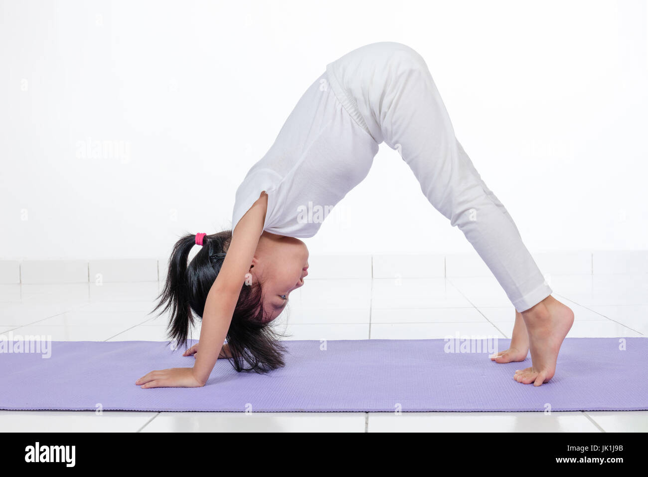 Asian Chinese little girl practicing yoga pose on a mat indoor Stock ...