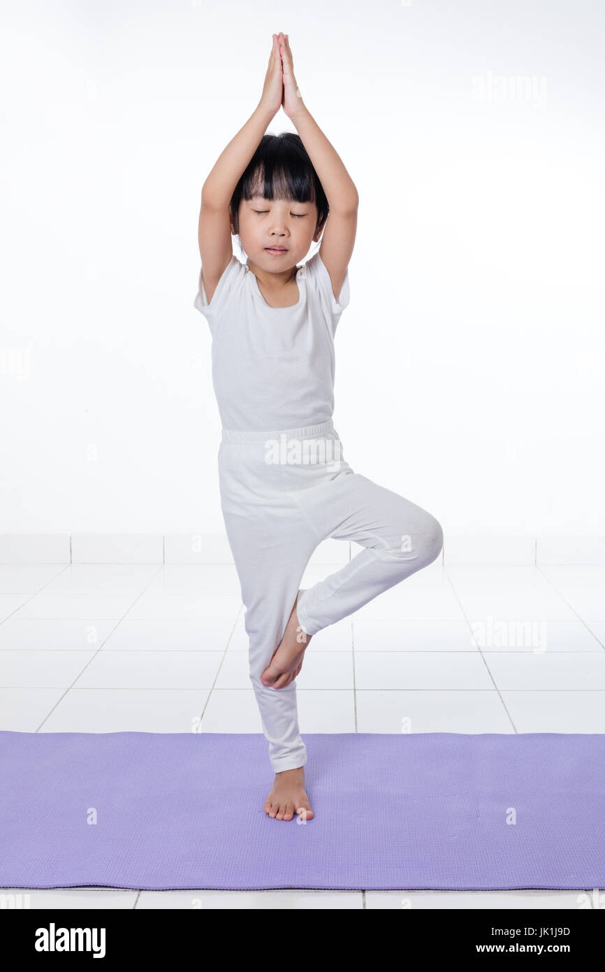 Asian Chinese little girl practicing yoga pose on a mat indoor Stock ...