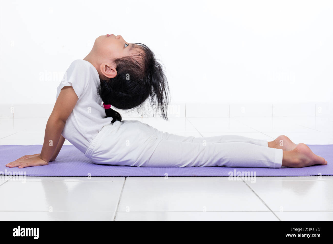 Asian Chinese little girl practicing yoga pose on a mat indoor Stock ...