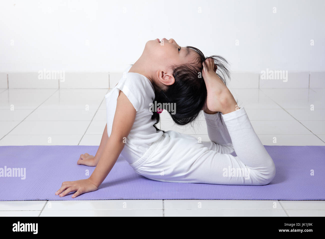 Asian Chinese little girl practicing yoga pose on a mat indoor Stock ...