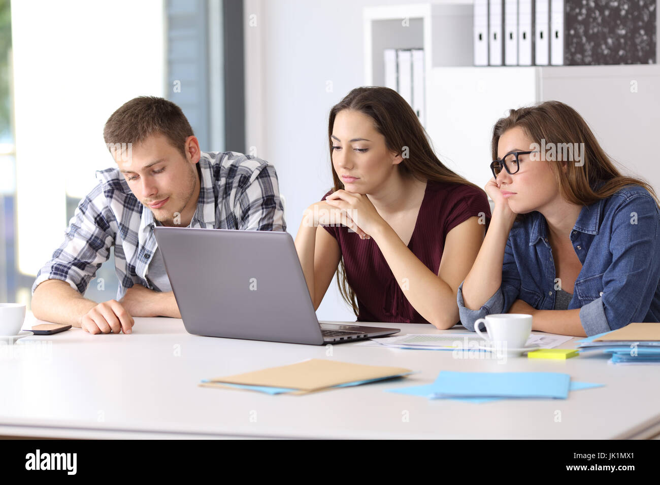 Three bored entrepreneurs waiting for a new project at office Stock ...