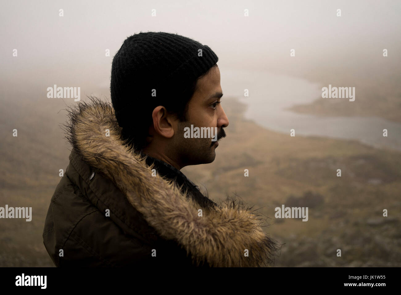 Man overlooking mountain lake Stock Photo - Alamy
