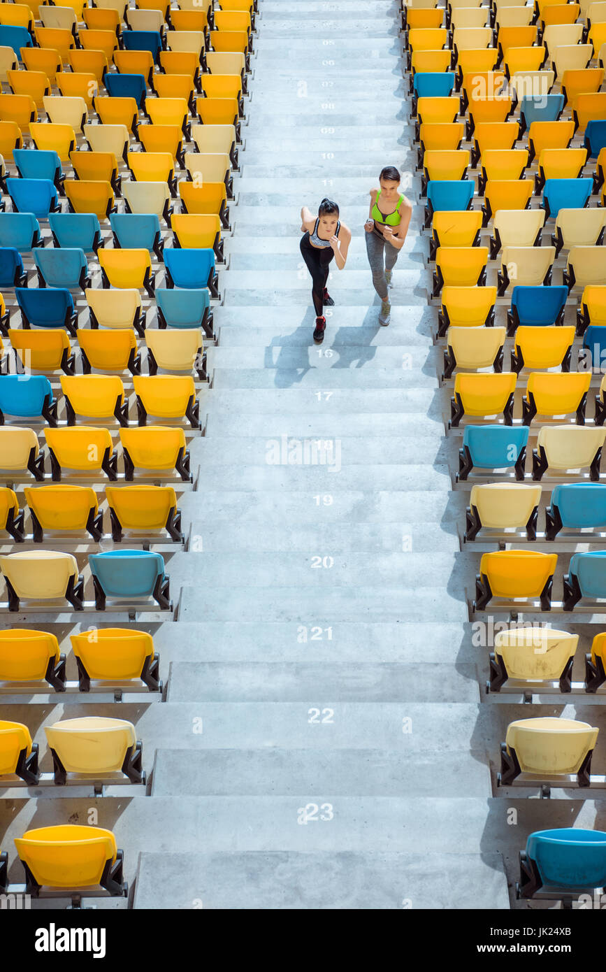 two sportswomen running on stadium stairs, running women concept Stock ...