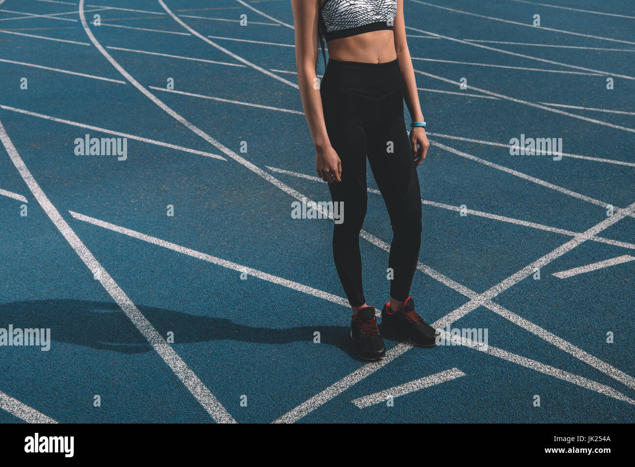 young sportswoman standing on running track stadium, running woman ...