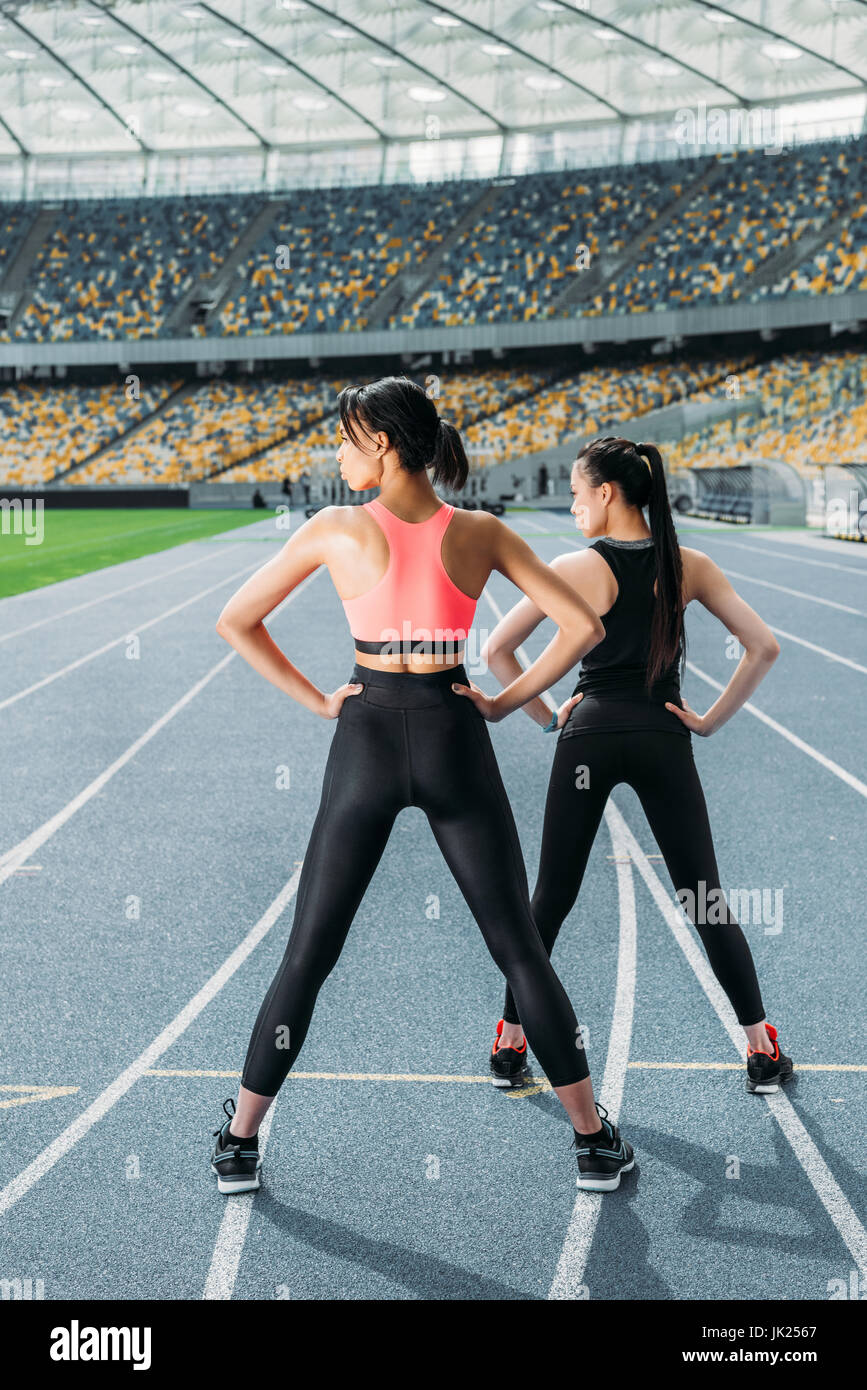 Athletic young women in sportswear exercising on running track stadium ...