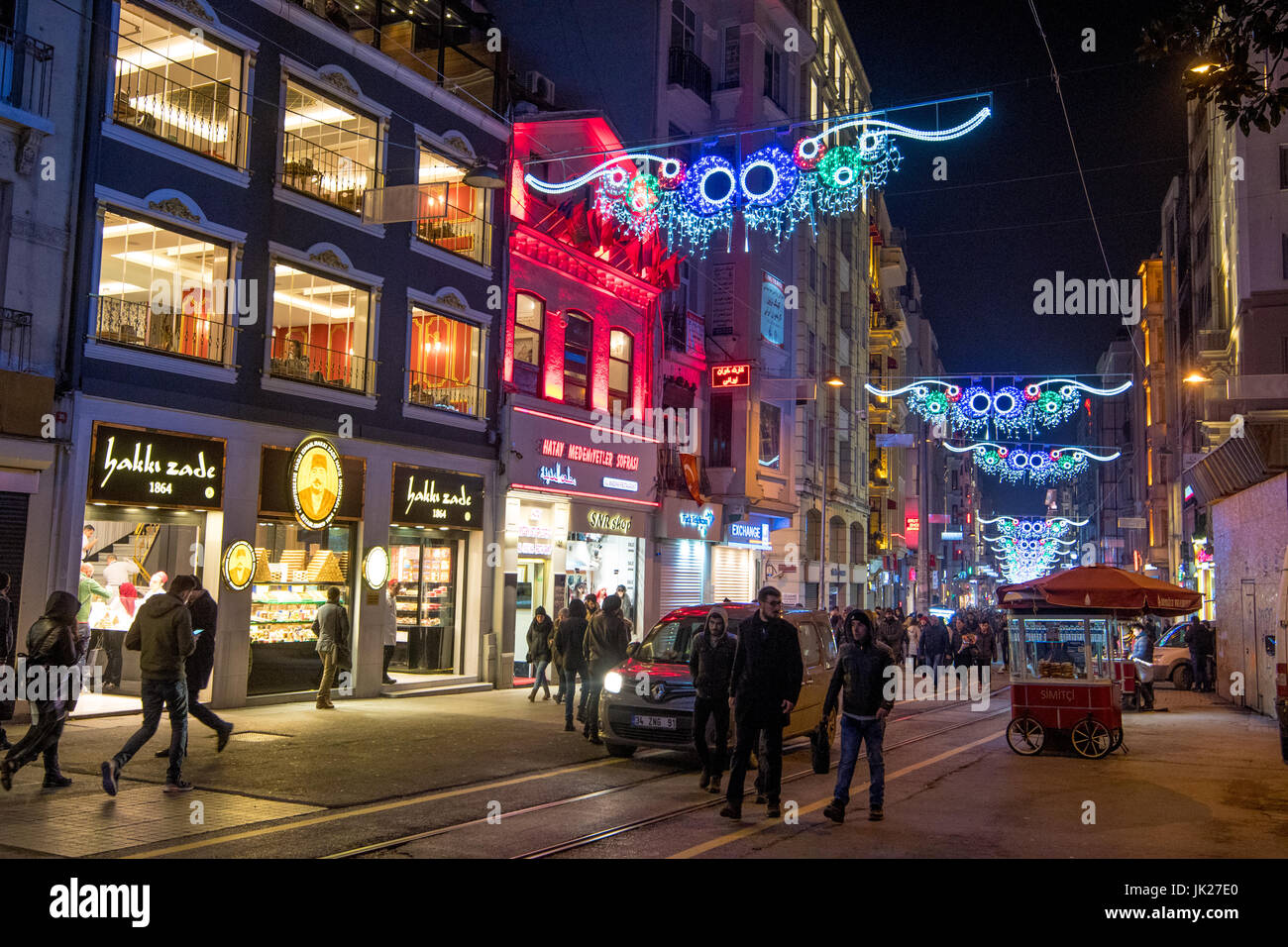 Tourists and locals walk along the shops and eateries in Taksim square ...