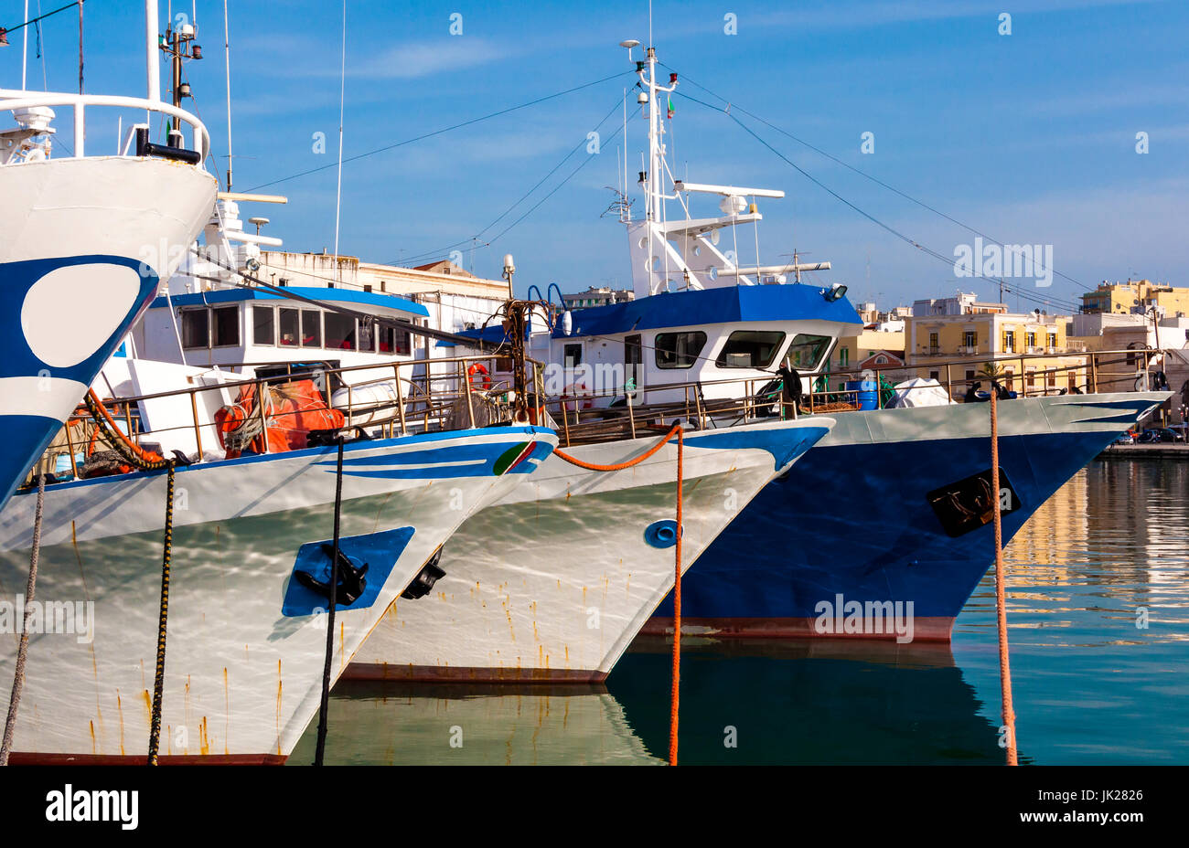 Fishing motorboats tied to mooring cleats of a port Stock Photo - Alamy