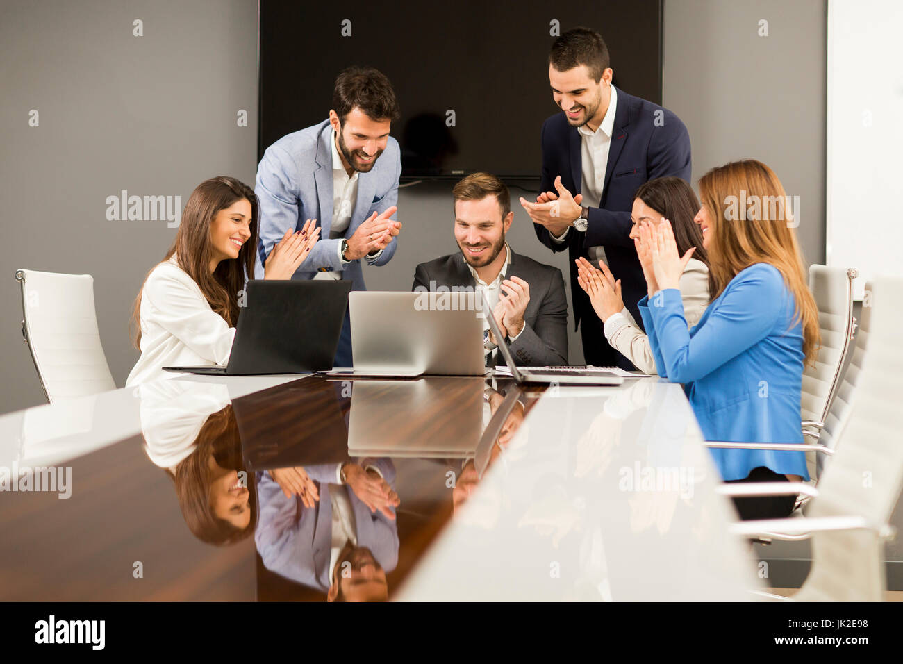 Young teamwork by the table in the office Stock Photo - Alamy