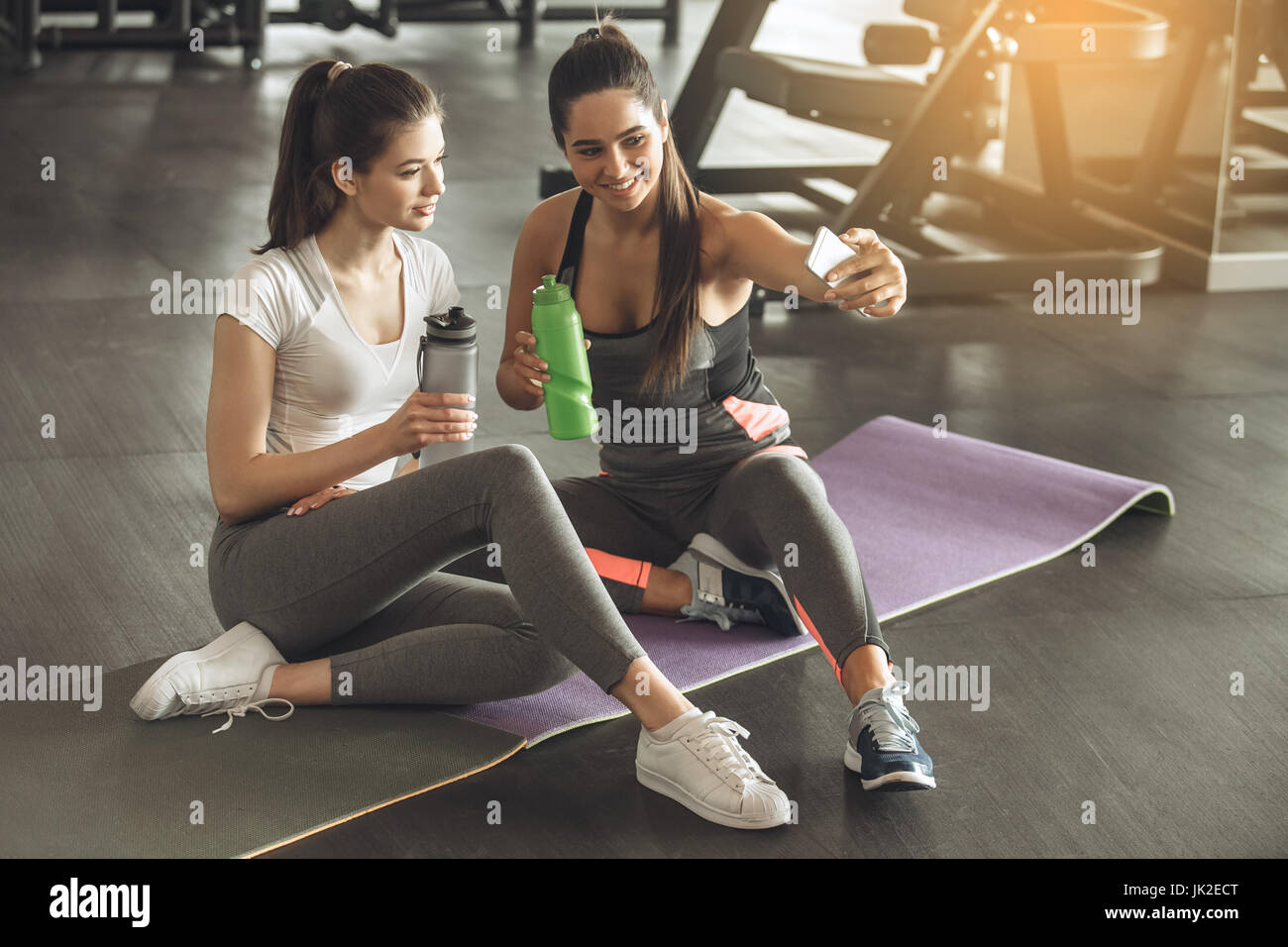 Young female friends exercise in the gym taking photos Stock Photo - Alamy