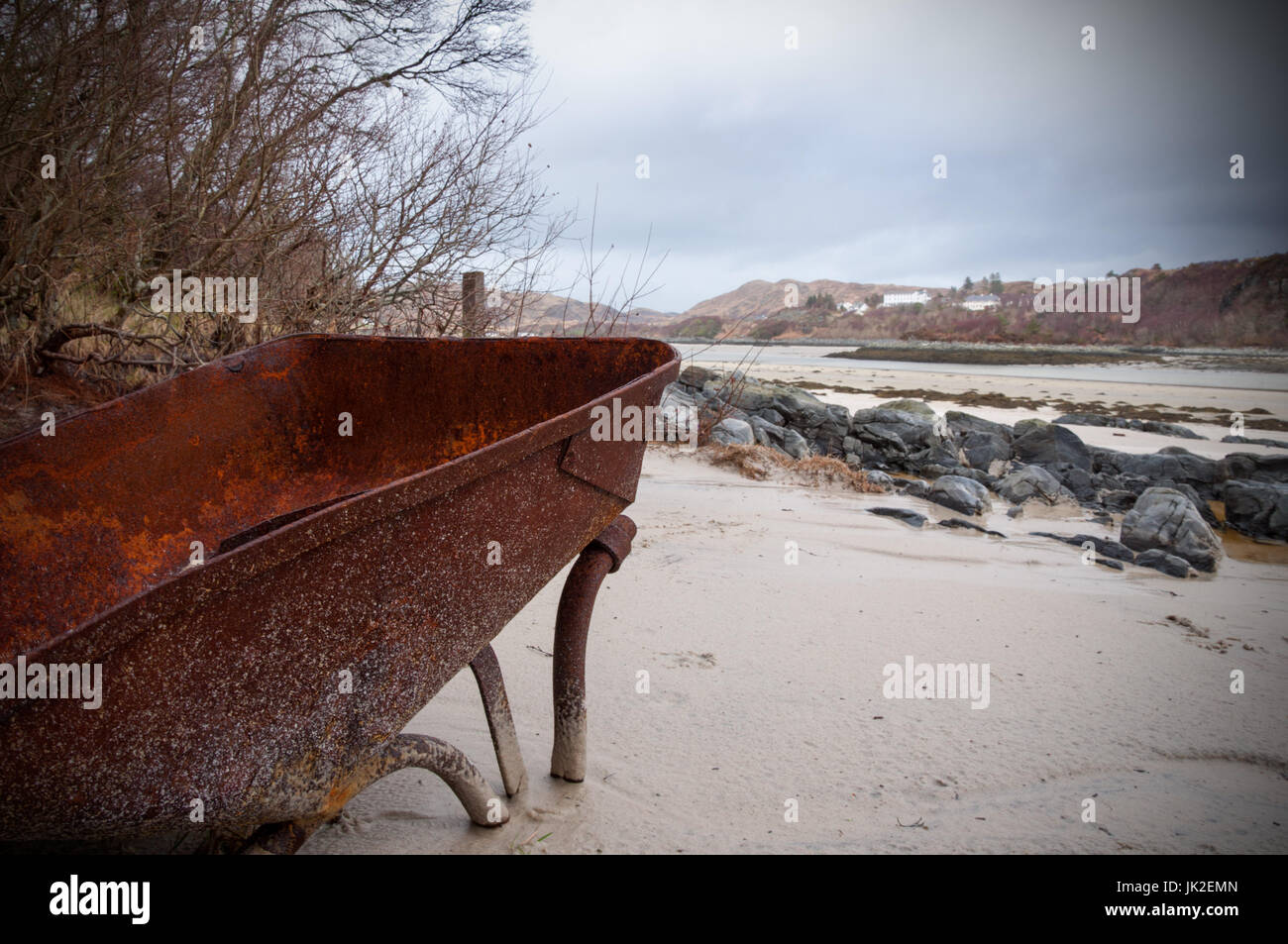 A rusty old wheelbarrow abandoned on the beach at Morar Bay in the ...