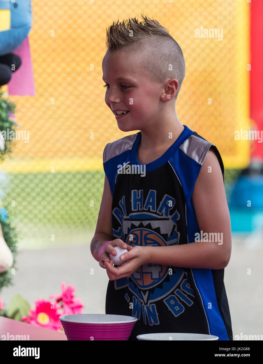 Young boy at the state fair playing a game of chance on the midway ...