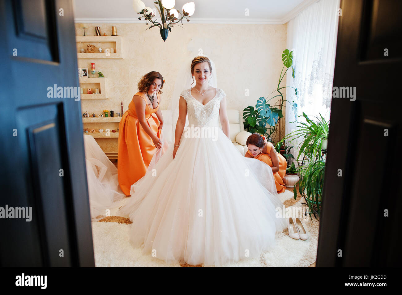 Bridesmaids helping bride to get ready for her wedding ceremony Stock ...