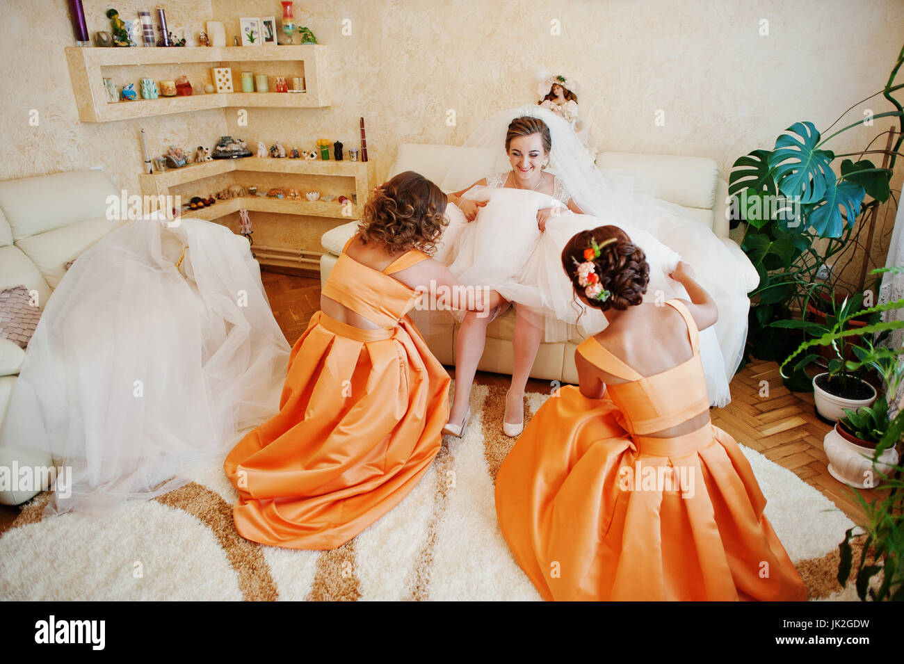 Bridesmaids helping bride to get ready for her wedding ceremony Stock ...