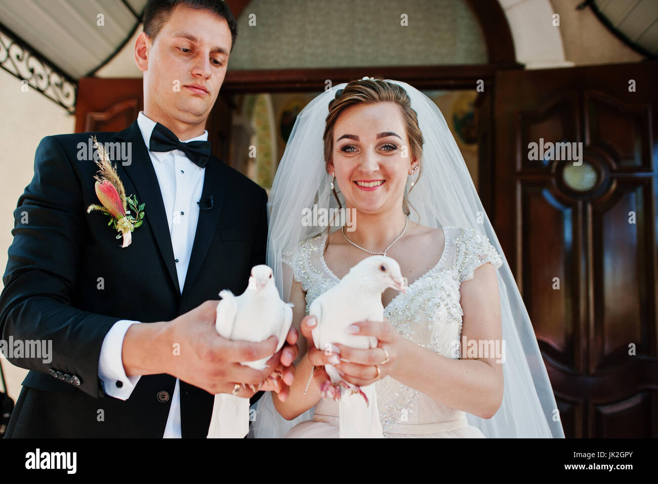 Awesome wedding couple releasing doves into the sky Stock Photo - Alamy
