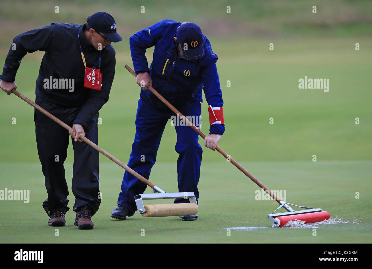 Groundstaff sweep the standing water on a green during day two of The ...
