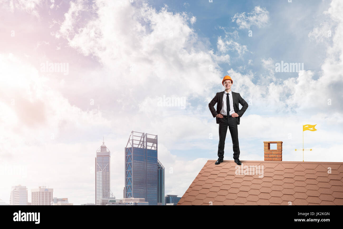 Engineer man standing on roof and looking away. Mixed media Stock Photo ...