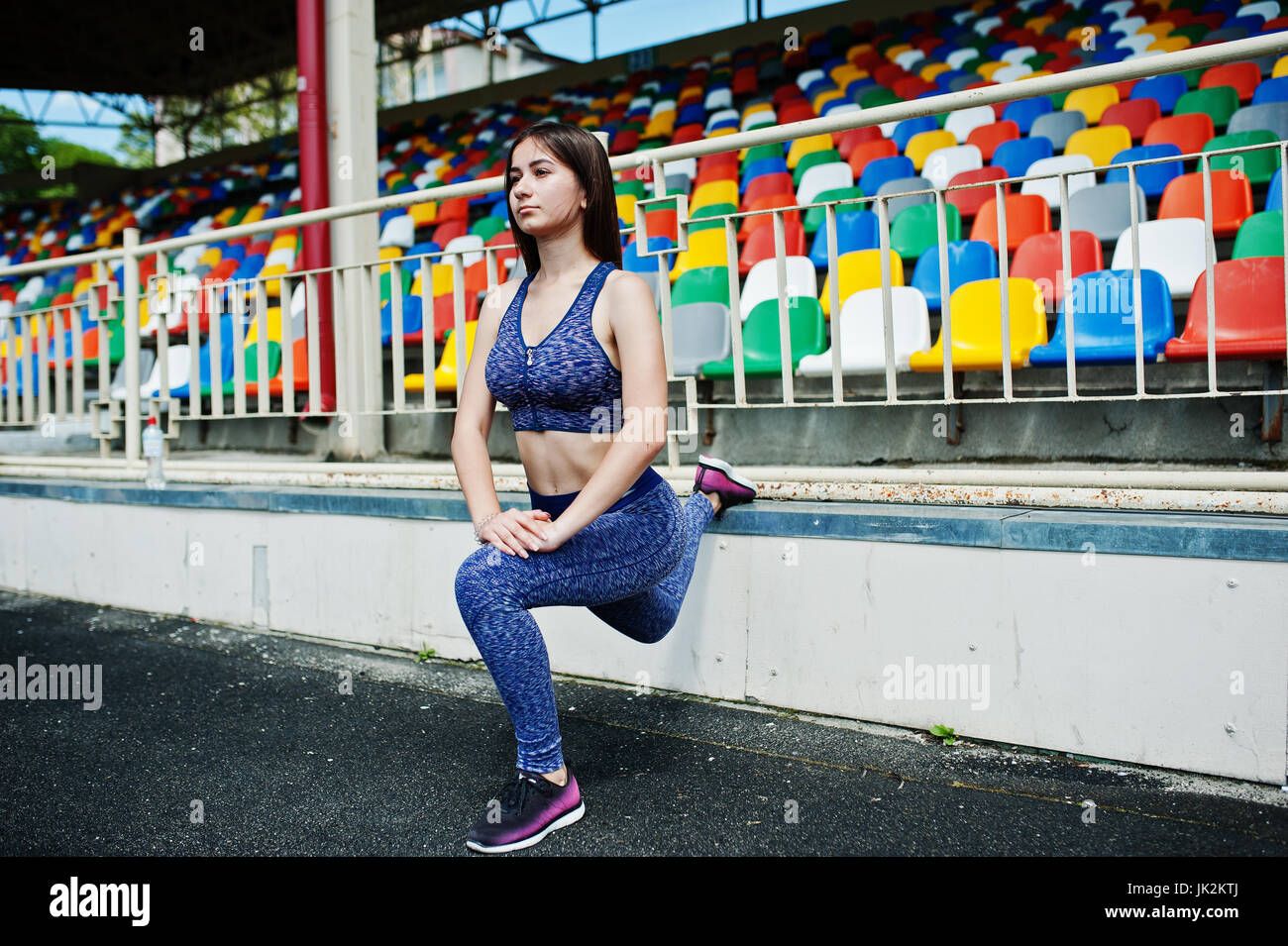 Portrait of a gorgeous girl doing squats in the stadium Stock Photo - Alamy