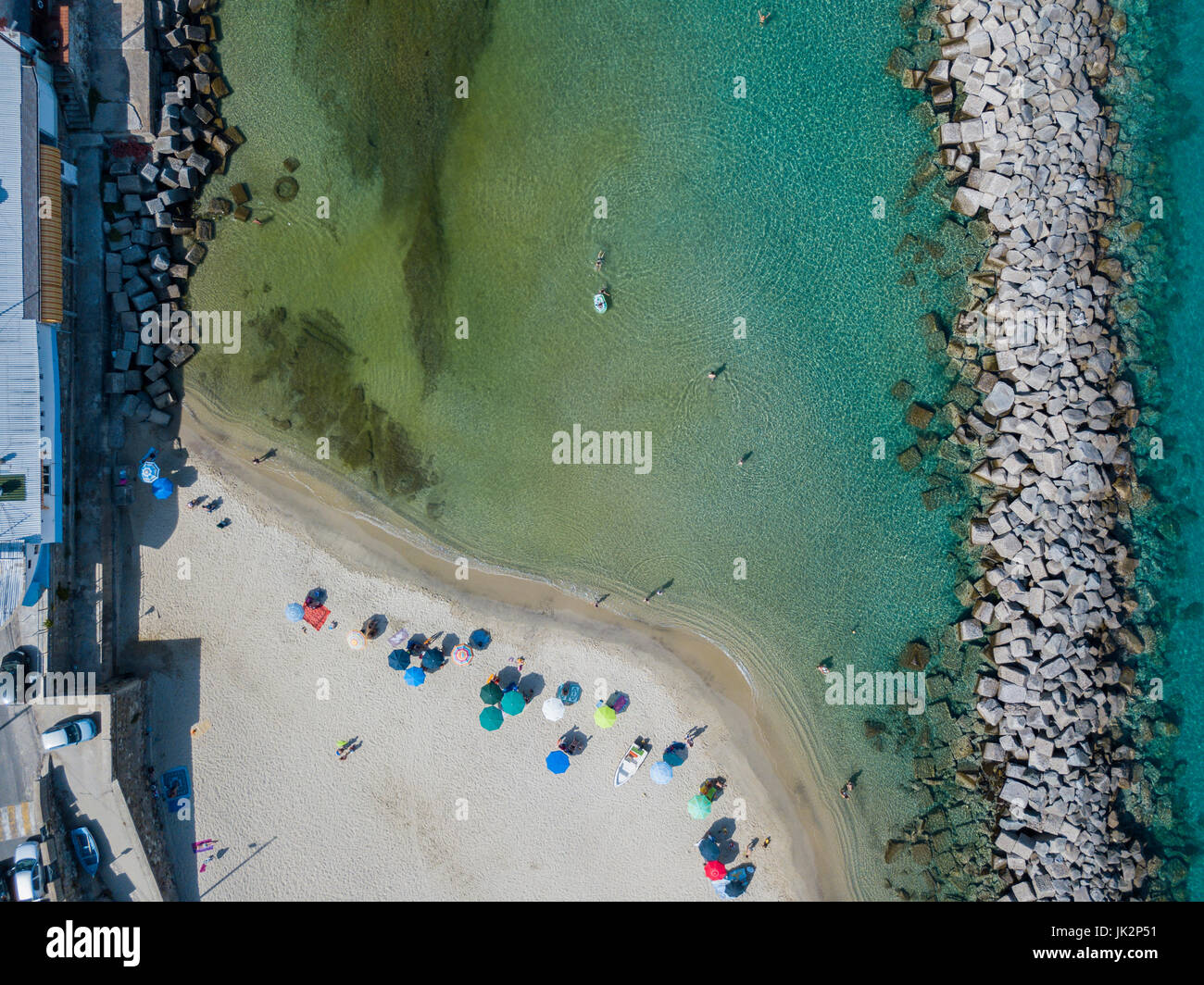 Aerial view of a beach and a pier with canoes, boats and umbrellas ...