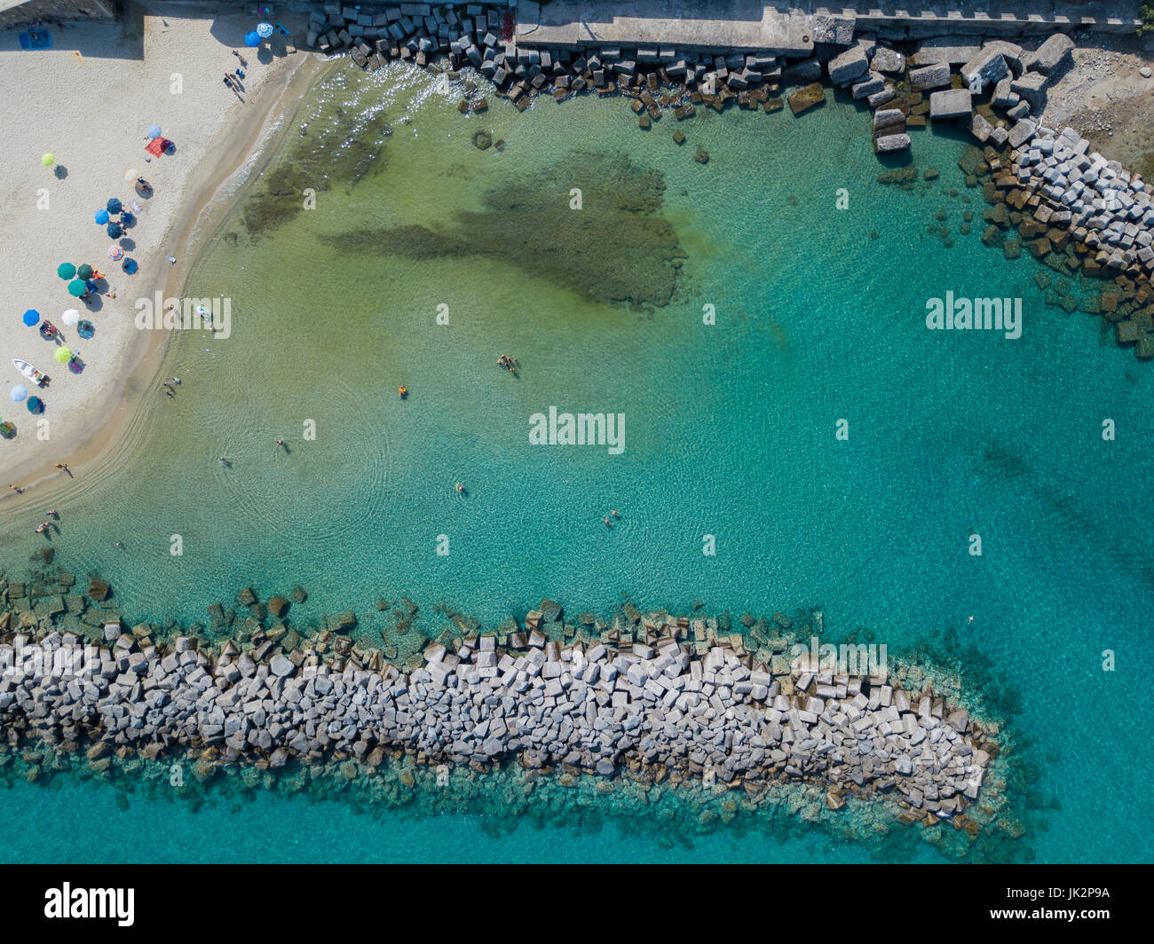 Aerial view of a beach and a pier with canoes, boats and umbrellas ...