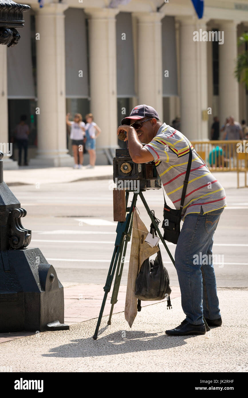 A man using a vintage camera on an old wooden tripod in Havana, Cuba ...