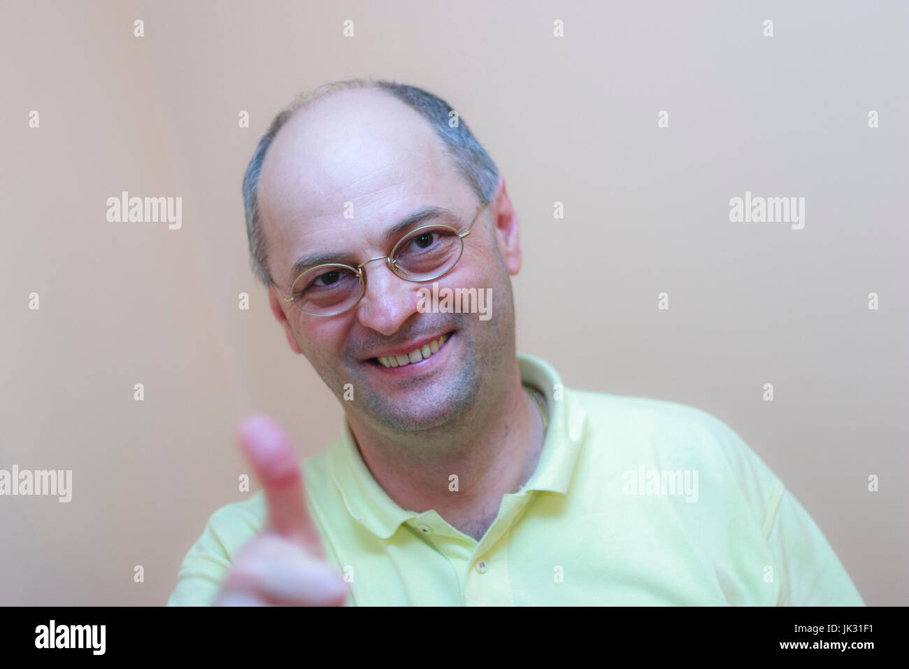 Mid adult man smiling showing thumb up sign Stock Photo - Alamy