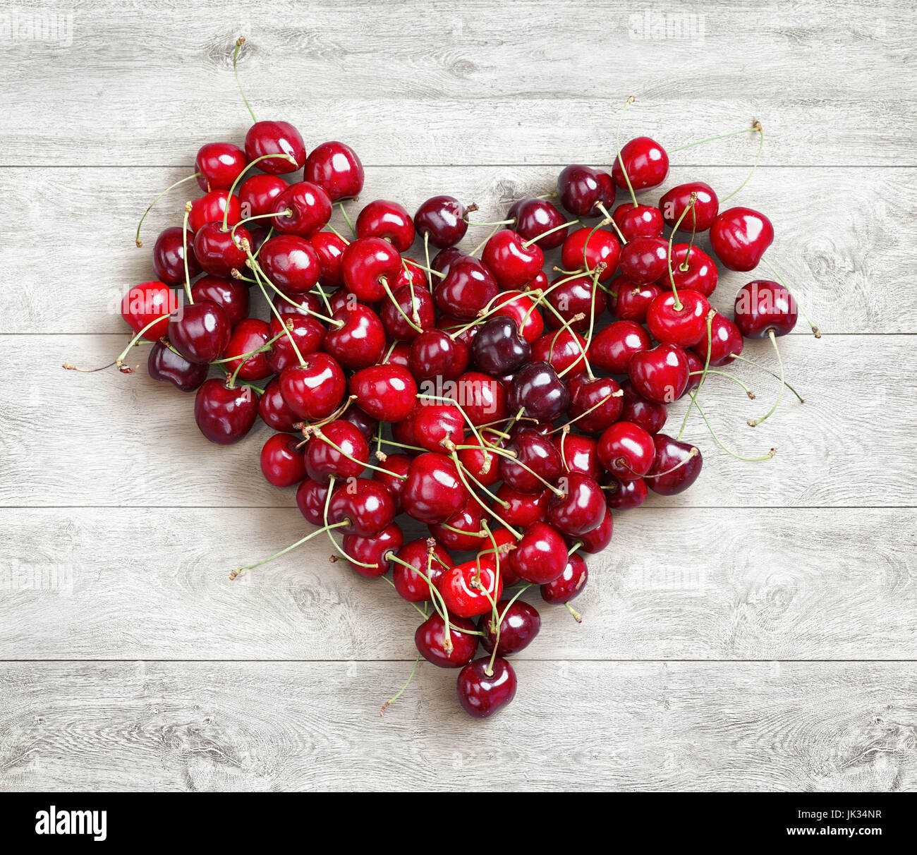 Heart shaped from cherry on white wooden background. Fruits diet ...