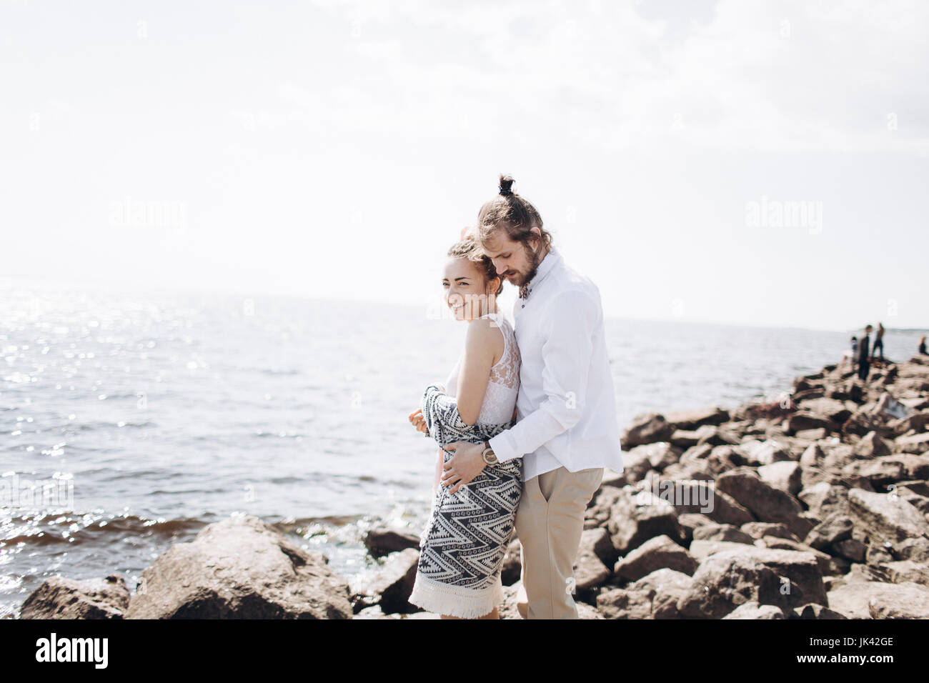 Middle Eastern couple hugging on rocks near ocean Stock Photo - Alamy