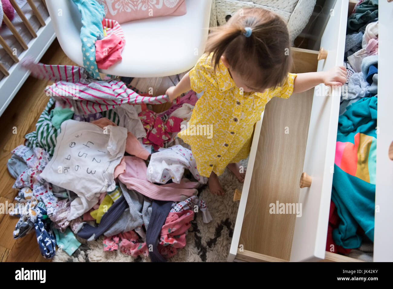 Caucasian baby girl removing clothing from dresser drawer Stock Photo ...