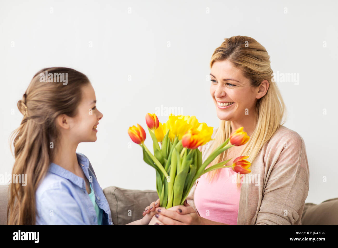 happy girl giving flowers to mother at home Stock Photo - Alamy