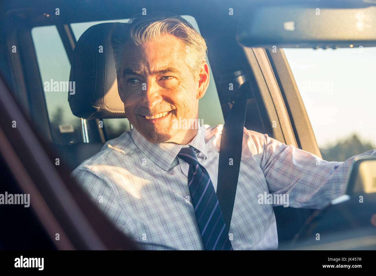 Smiling Caucasian businessman driving car Stock Photo - Alamy