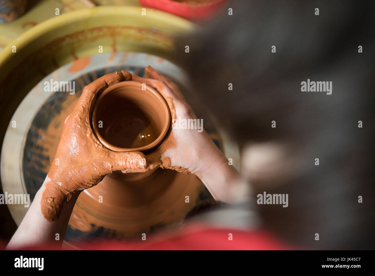 Caucasian woman shaping pottery clay on wheel Stock Photo - Alamy