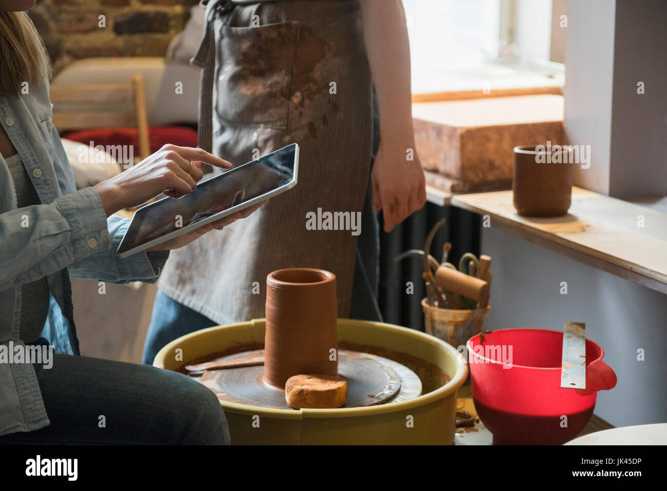 Caucasian women using digital tablet near pottery wheel Stock Photo - Alamy