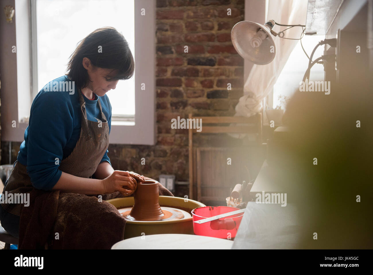Caucasian woman shaping clay on pottery wheel Stock Photo - Alamy