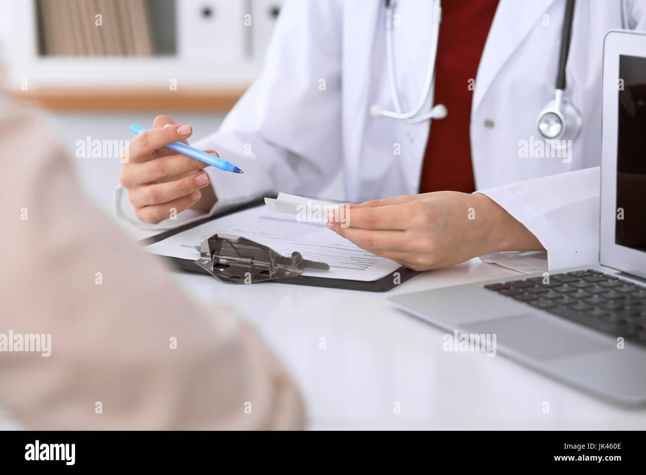Close up of a female doctor pointing into an application form while ...