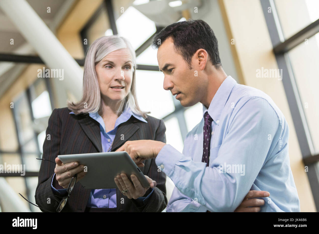Curious business people using digital tablet Stock Photo - Alamy