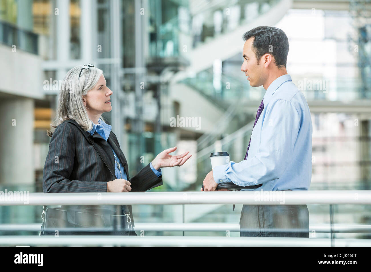 Serious business people talking in lobby Stock Photo - Alamy