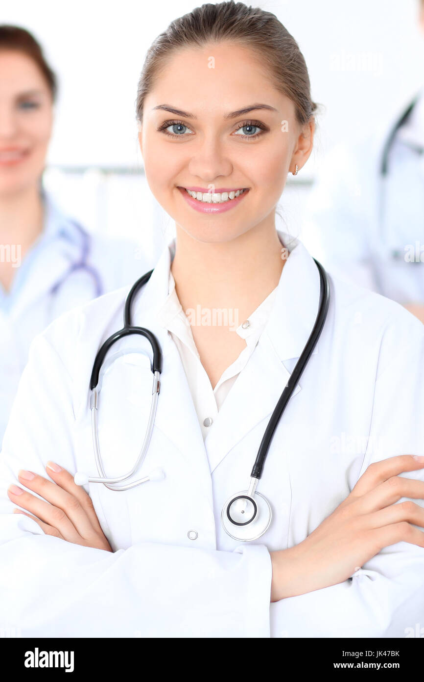 Happy female doctor with medical staff at the hospital. Successful team ...