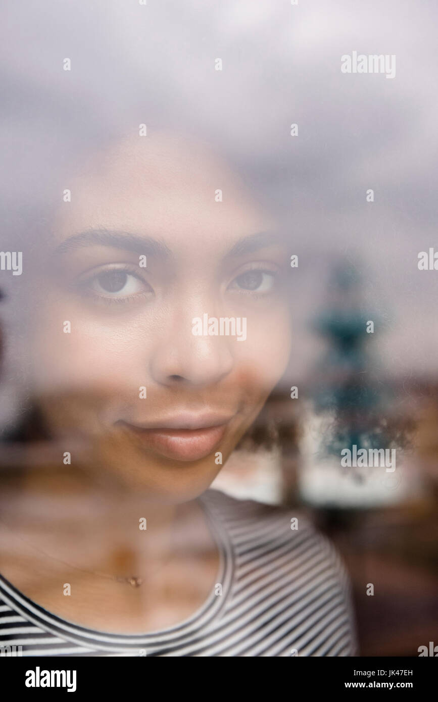 Smiling African American woman behind window Stock Photo - Alamy
