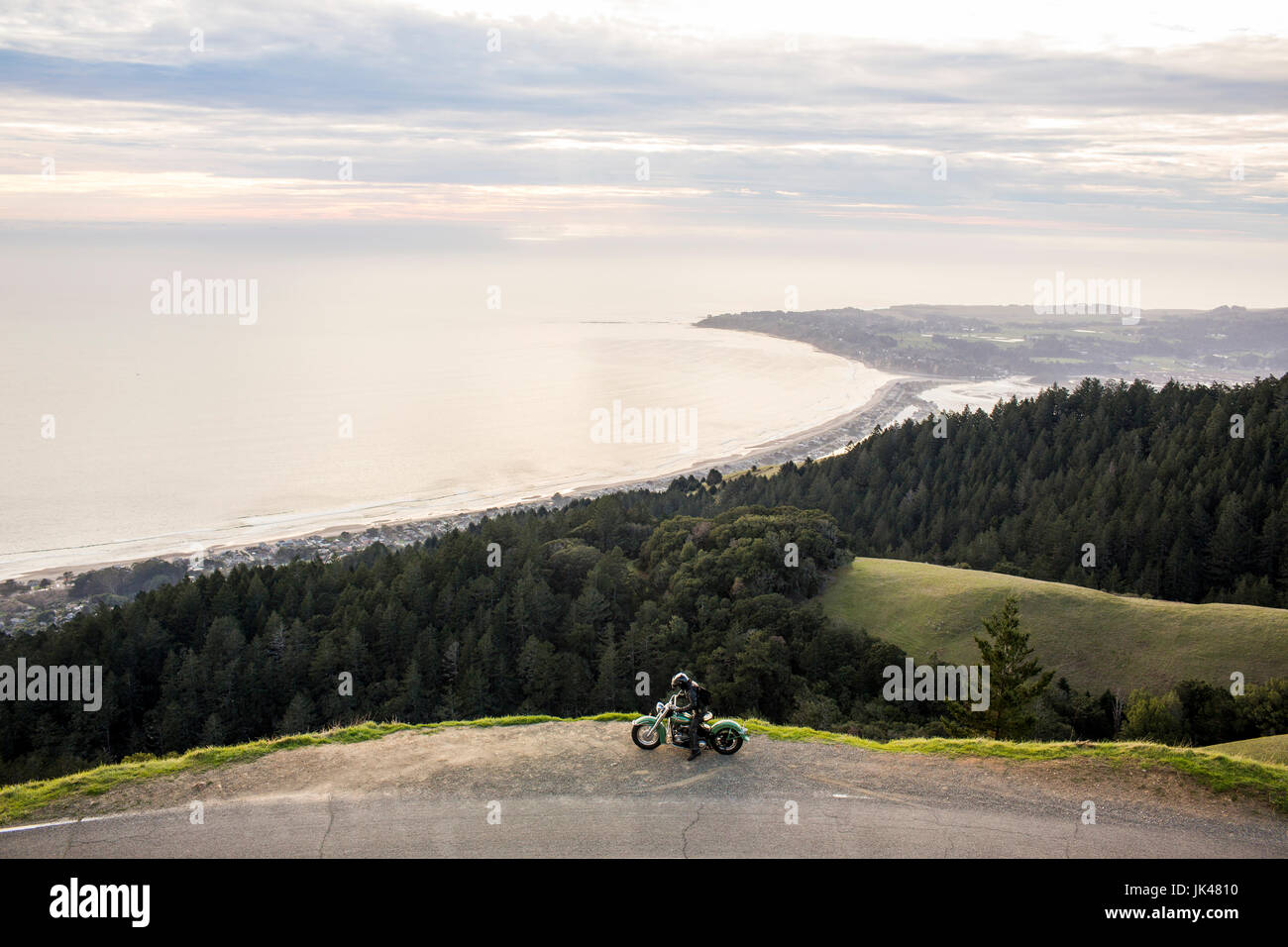 Person with motorcycle at edge of cliff near ocean Stock Photo - Alamy