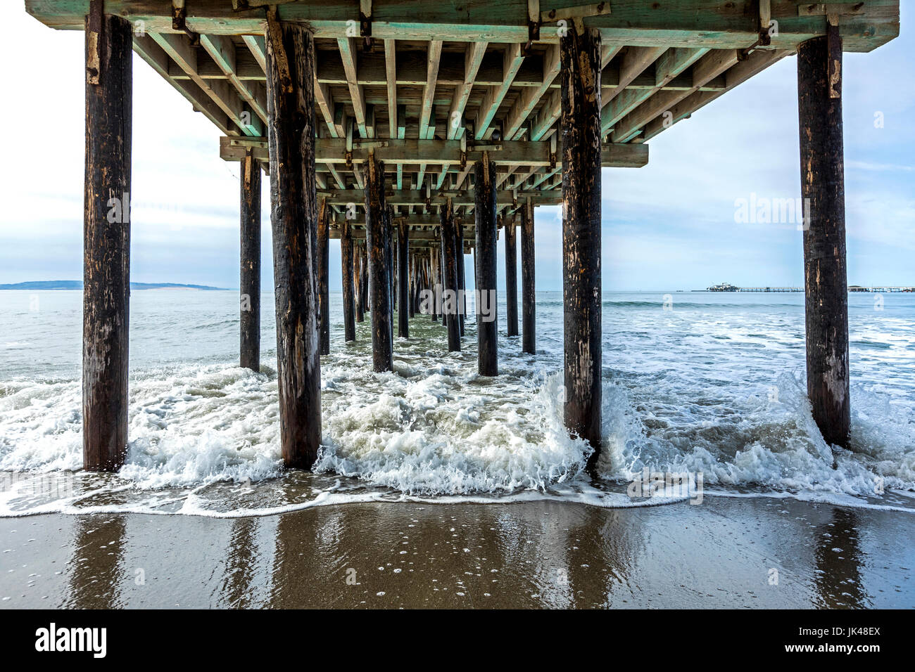 Waves splashing on pilings of wooden pier at beach Stock Photo - Alamy